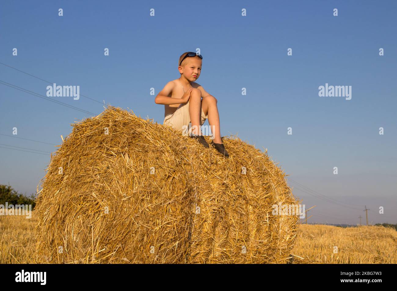haystack sitting boy,Little nice boy shorts and modern sits on a ...