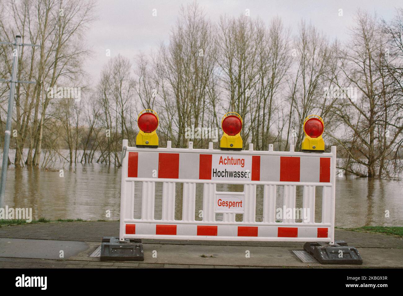 barrier with a sign reading 'flood warning' near the flooded banks of ...