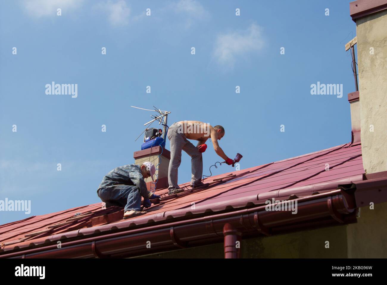 Son help father in painting the roof of the house Stock Photo - Alamy
