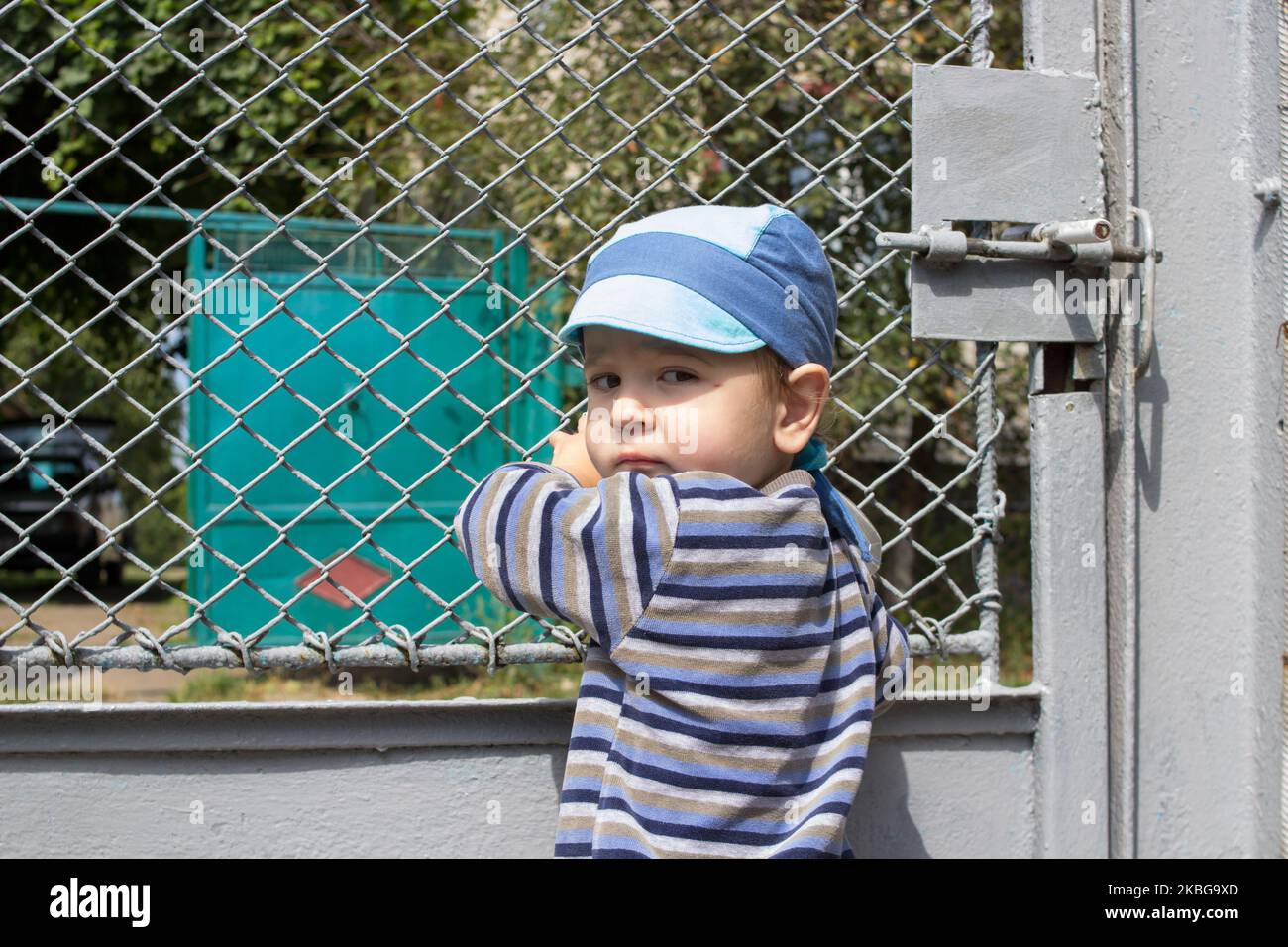boy stand disappointed in closed metal gate Stock Photo - Alamy