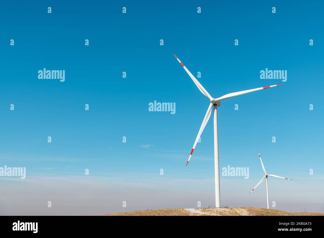 Multiple wind turbines standing on a hill at sunrise and generating ...