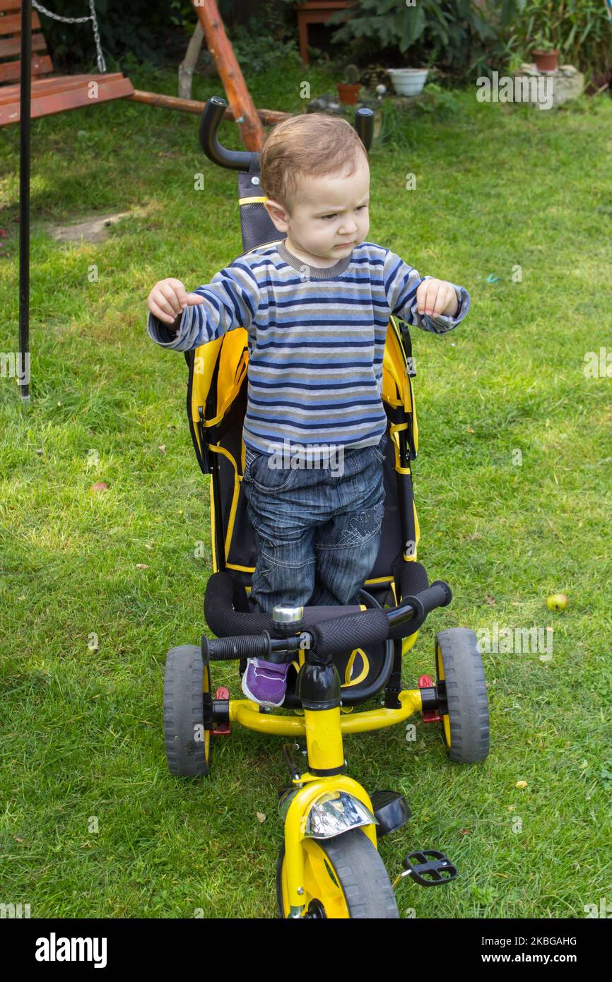 On a yellow tricycle was a little boy Stock Photo - Alamy
