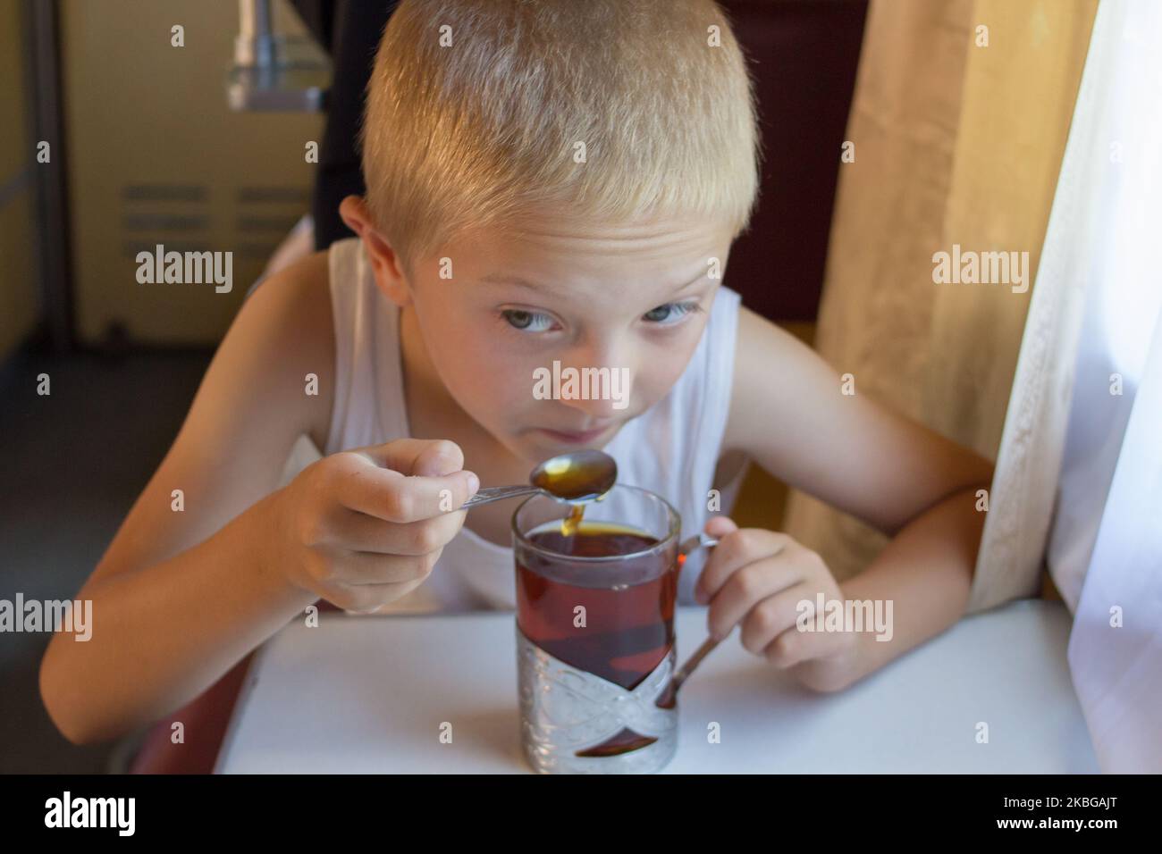 The boy drinks tea in the train in the summer Stock Photo - Alamy