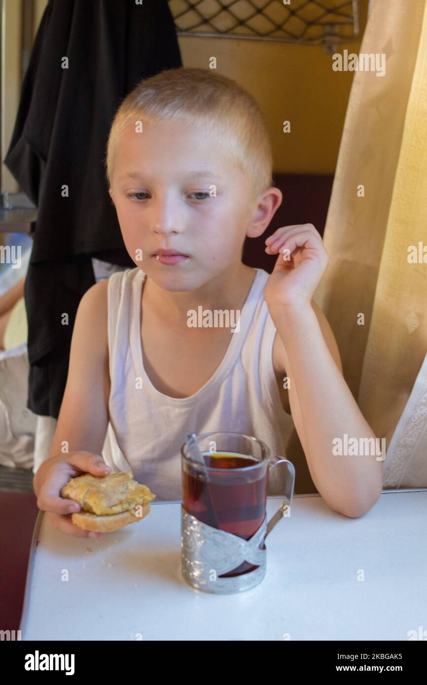 boy travels by train during summer holidays, eating a sandwich and ...
