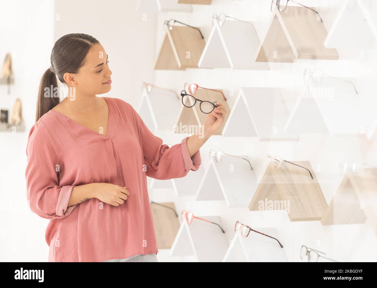 Optometry, vision and woman choosing glasses in retail optical store ...