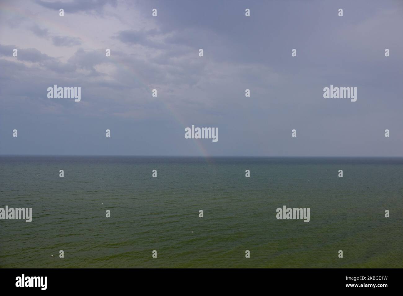 A beautiful rainbow appears over the tropical Pacific Ocean as sunlight ...