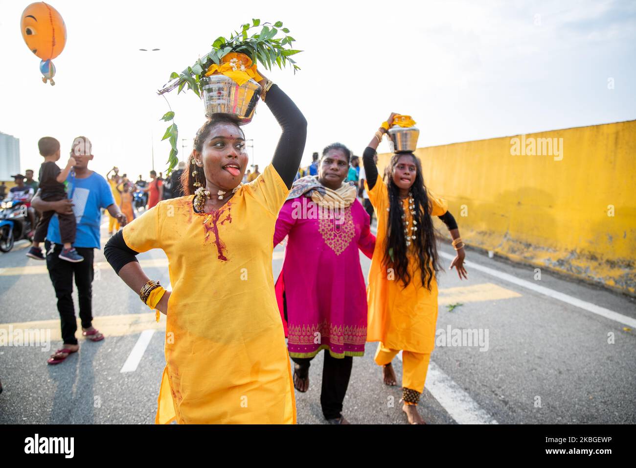 Hindu devotees carry pots of milk on their heads prior to walking up to ...