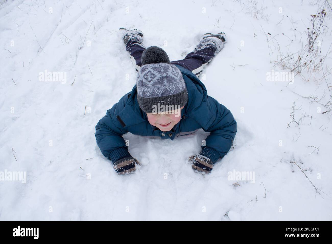 the boy fell to the snow forward on the stomach Stock Photo - Alamy