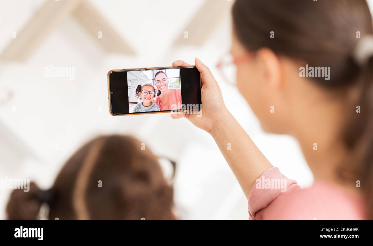 Family phone selfie, mother and girl at optometry hospital taking ...