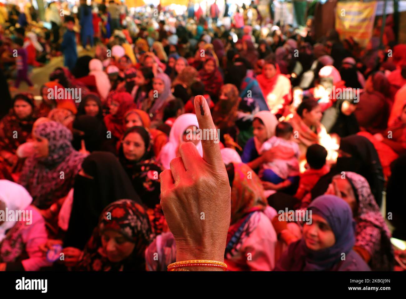 A woman shows her index finger inked after casting her vote in the ...