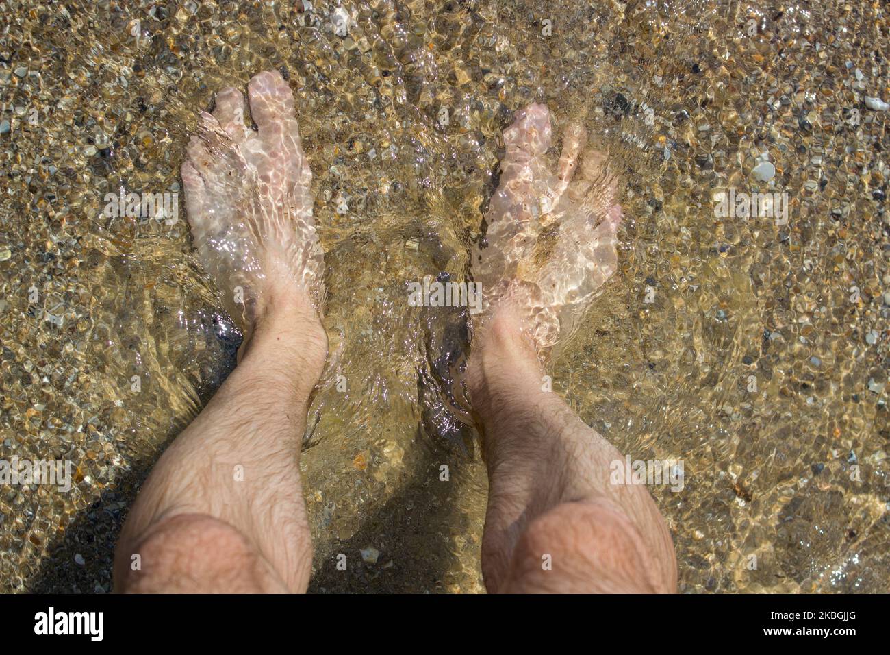 Vacation on summer ocean beach, feet on sea sand with bubble float wave ...