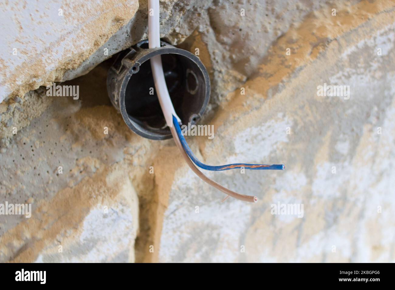 Electricity socket installation on white wall closeup Stock Photo - Alamy