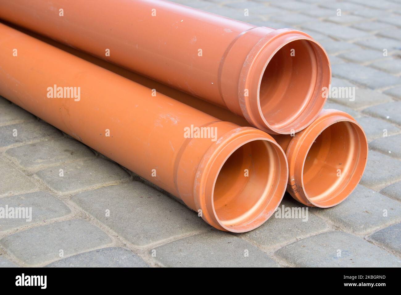 Three new pipes red sewer on paved Stock Photo - Alamy
