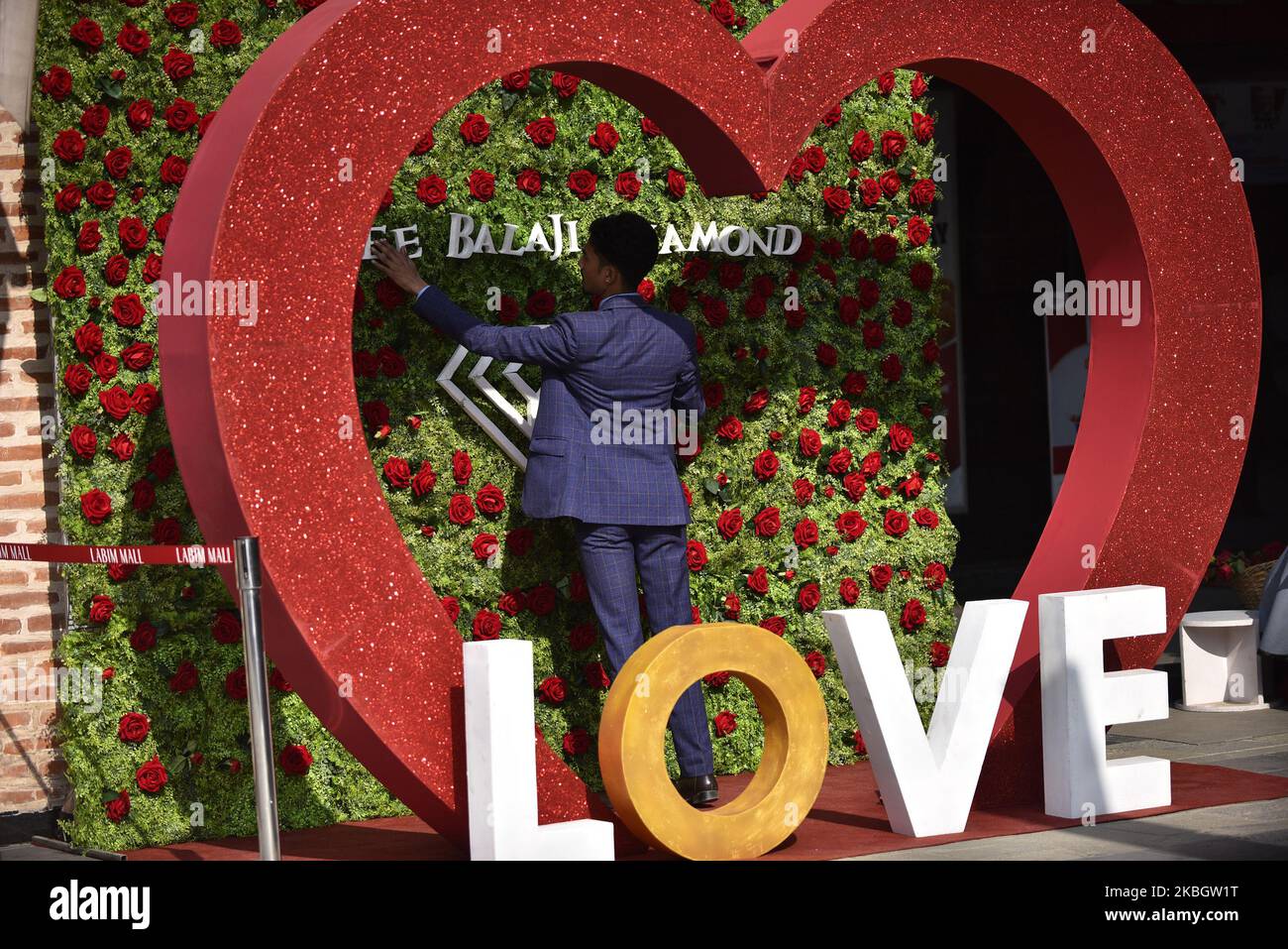 A Man making photo booth of Love sign and Rose Flowers in Labim Mall ...