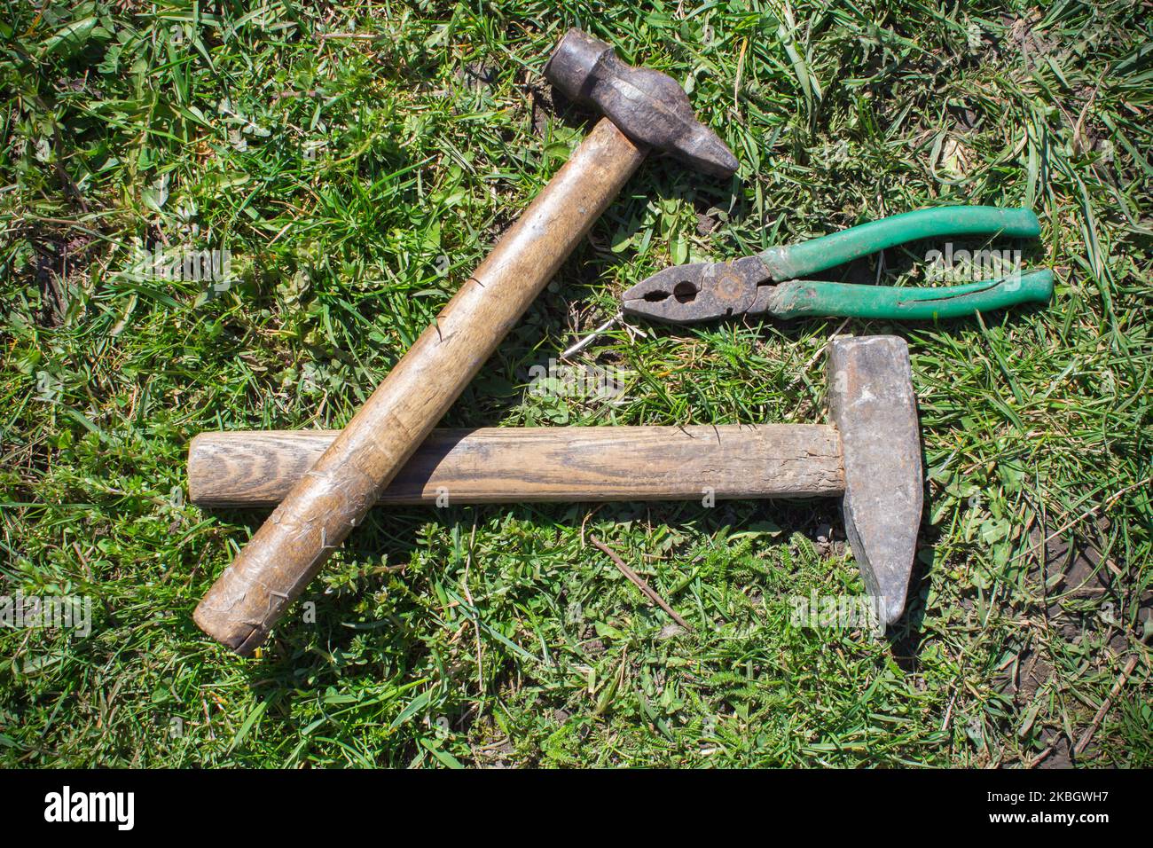 Tools on a rustic wooden background and grass Stock Photo - Alamy