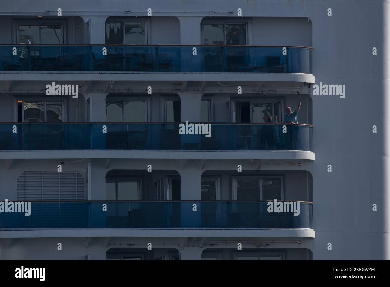 Passengers of the Diamond Princess cruise ship stand on their cabins ...