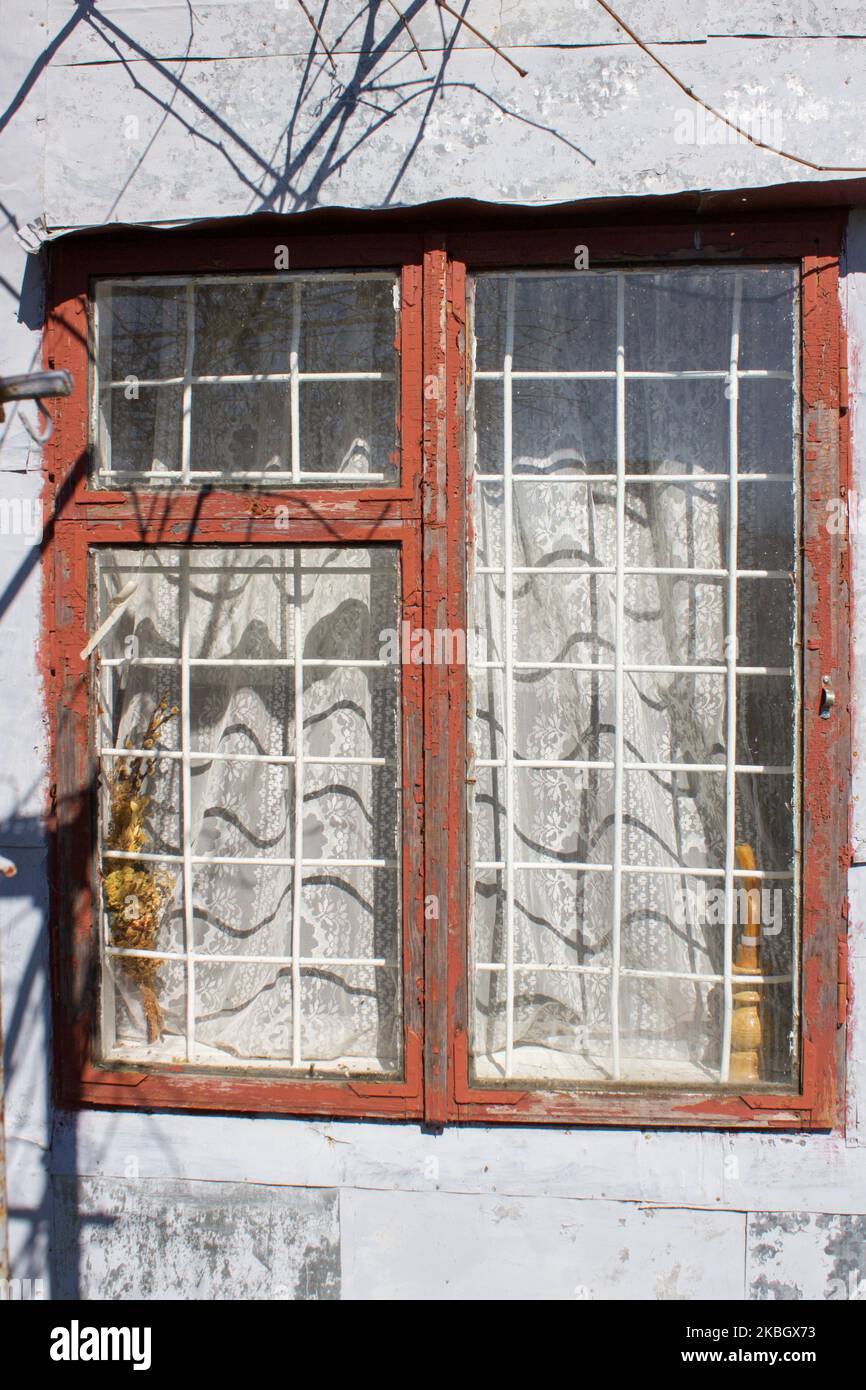 Old wooden window with white curtains in a traditional house in the ...
