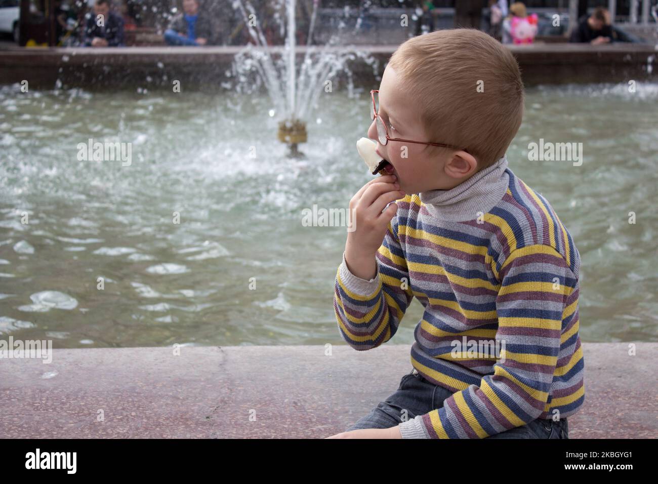 Boy biting cold ice cream on white background Fountain Stock Photo - Alamy
