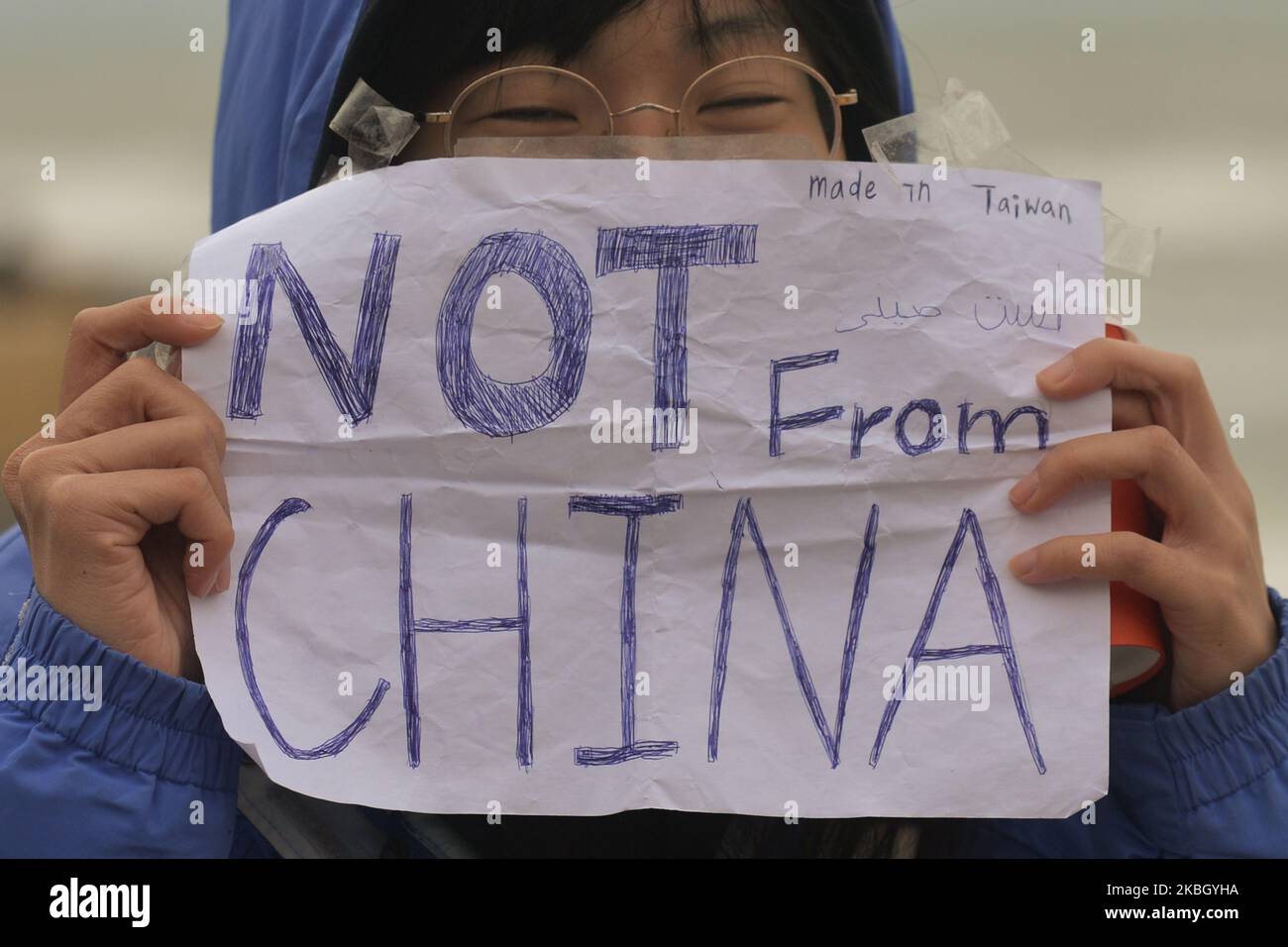 Taiwanese tourist carries a sign 'Not From China' during a walk in Tel ...