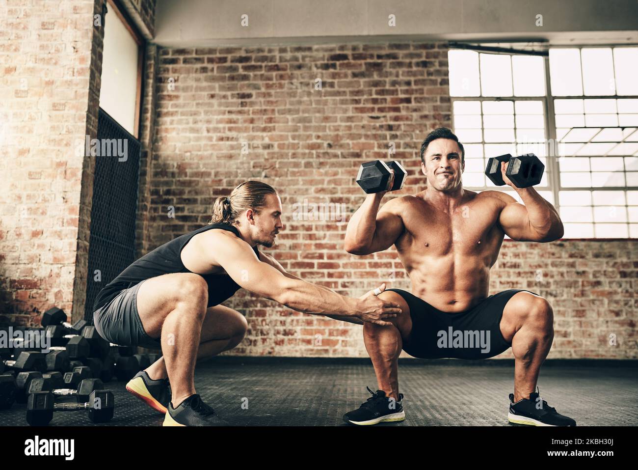 Keep your legs horizontal. two fit and determined young men helping ...