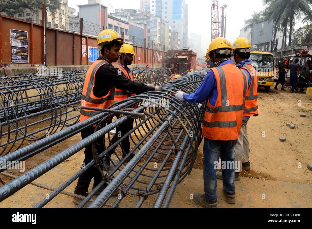 Bangladeshi workers preparing reinforcing steel at a construction site ...