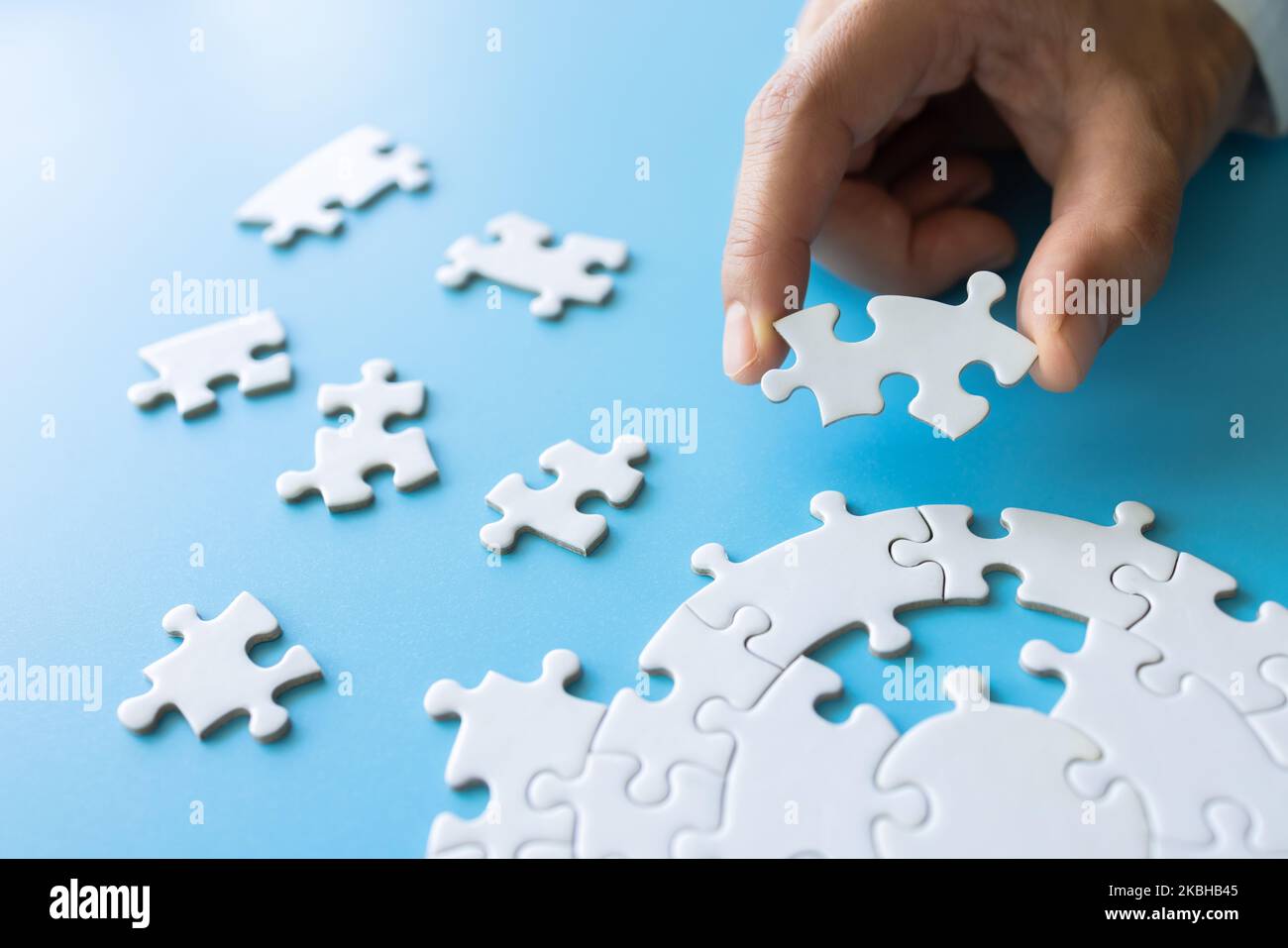 Hand put the last piece of jigsaw puzzle to complete the mission ...