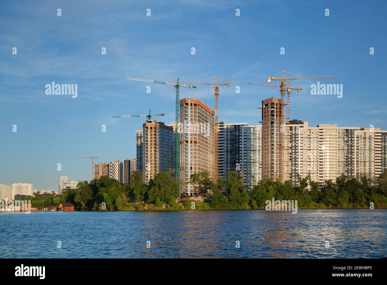 view from the side of the shore on the construction of a new high-rise ...