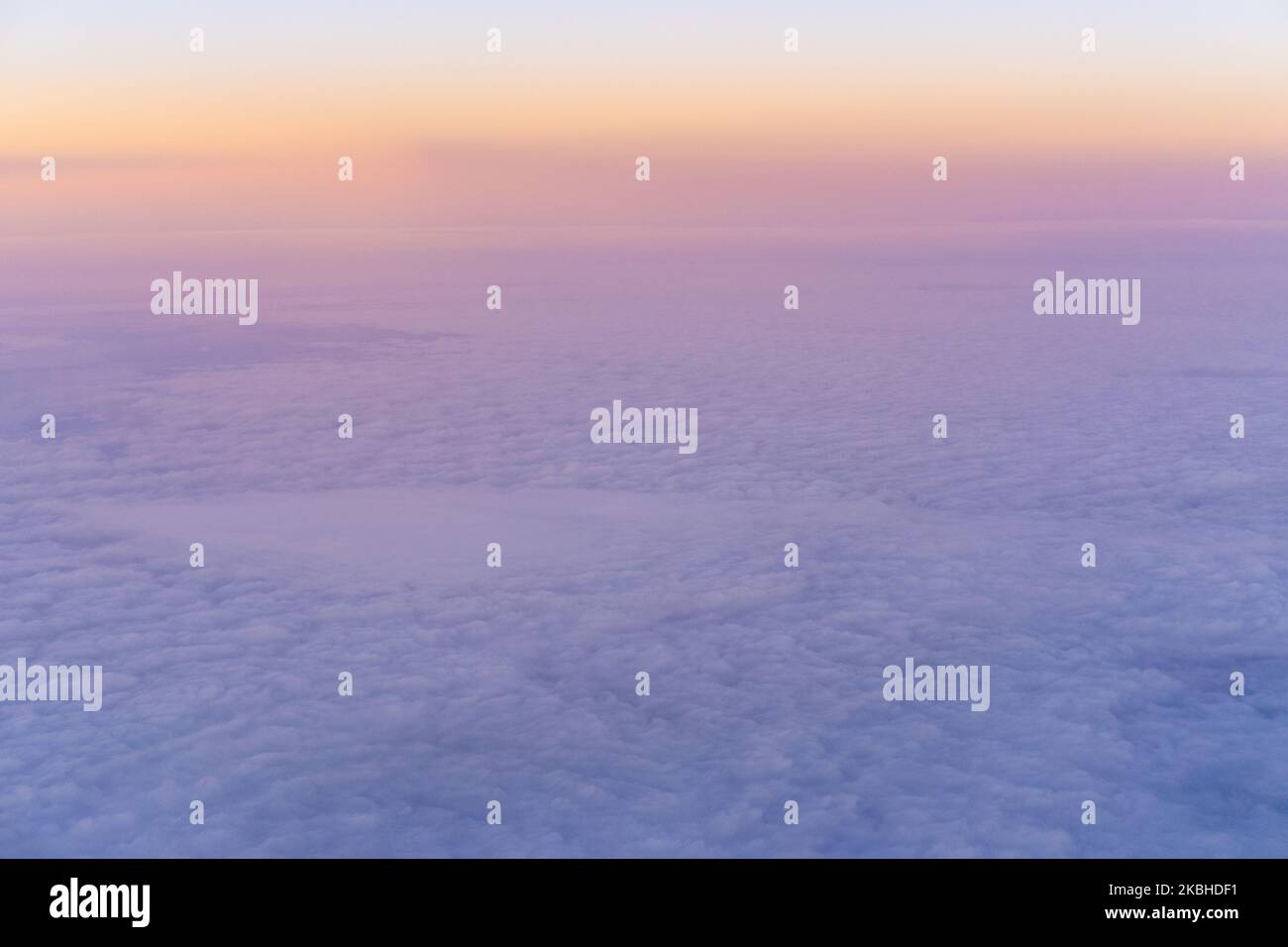 Aerial view of bright yellow sunset over pink purple dense clouds with ...