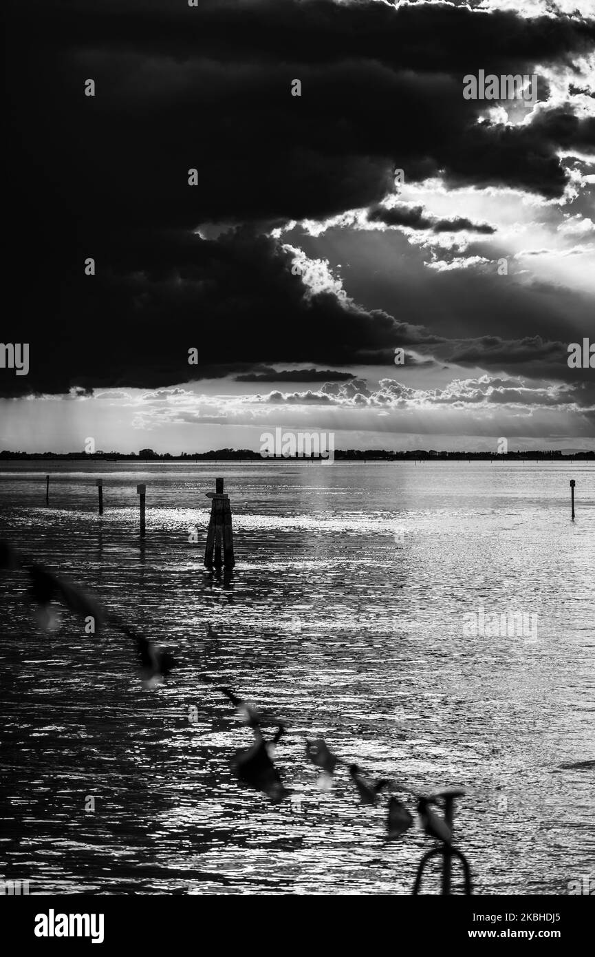 Towards the sunset. Marano lagoon late summer colors. Clouds and sun ...