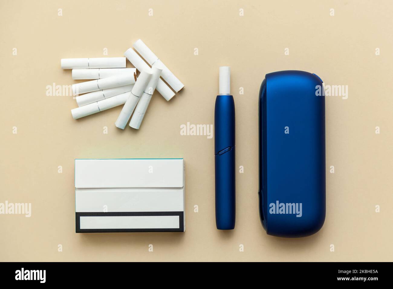 Electronic blue IQOS cigarette, with box with cigarettes on a beige ...