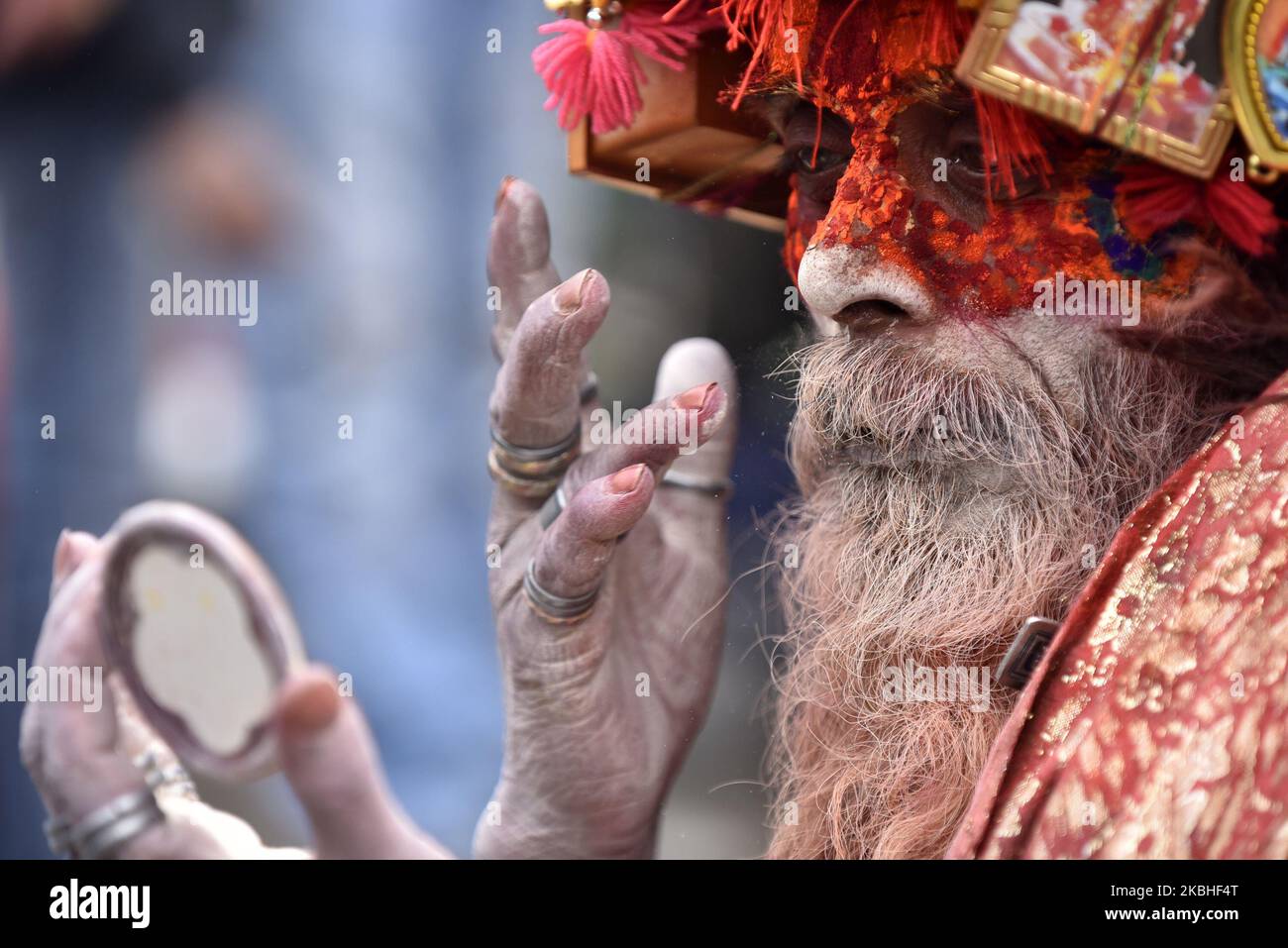 A Hindu Sadhu or Holy Man smears powder on his face during Maha ...