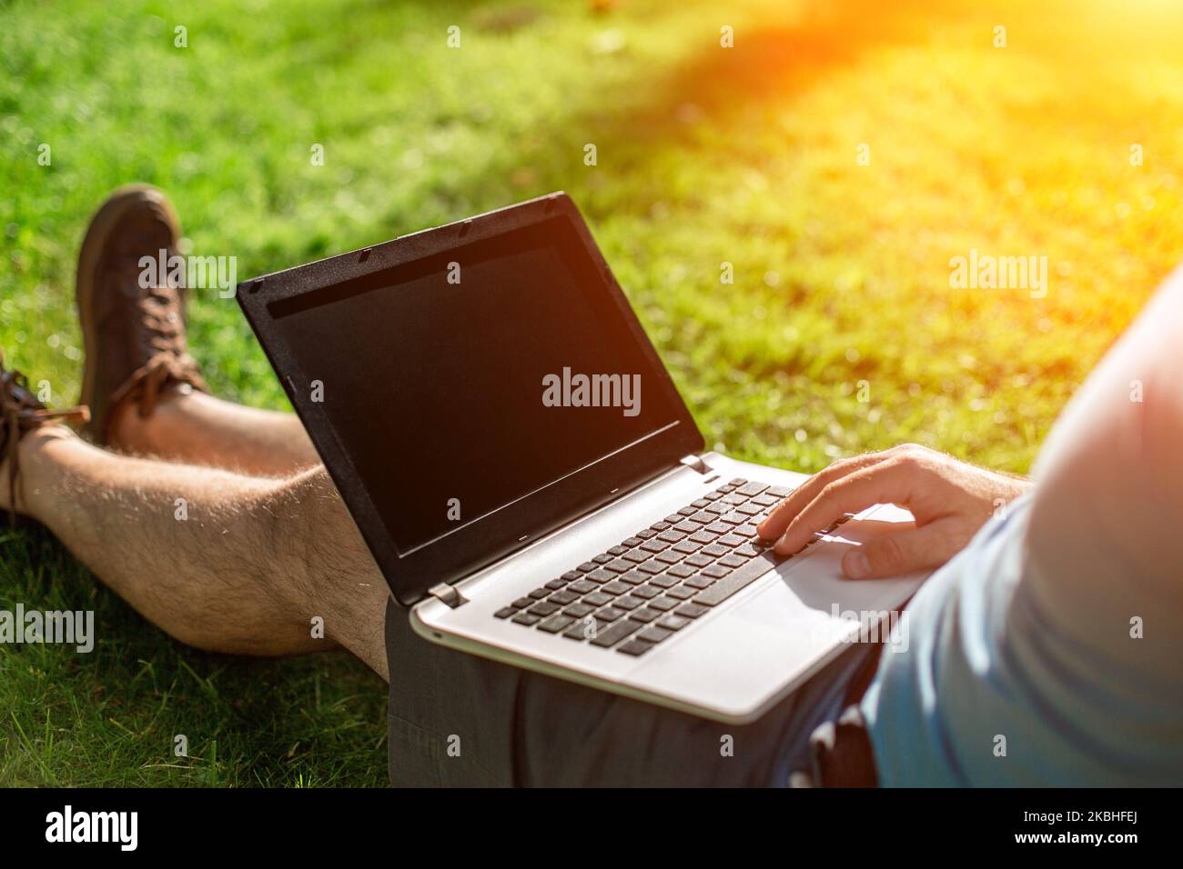 Cropped shot of man using laptop with blank screen while sitting on ...