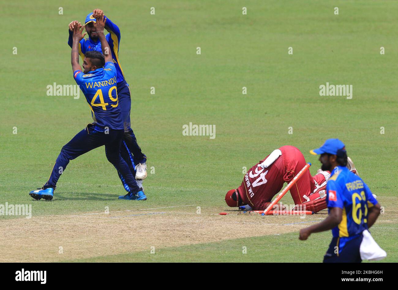 West Indies cricketer Darren Bravo crashes in to the stumps as he is ...