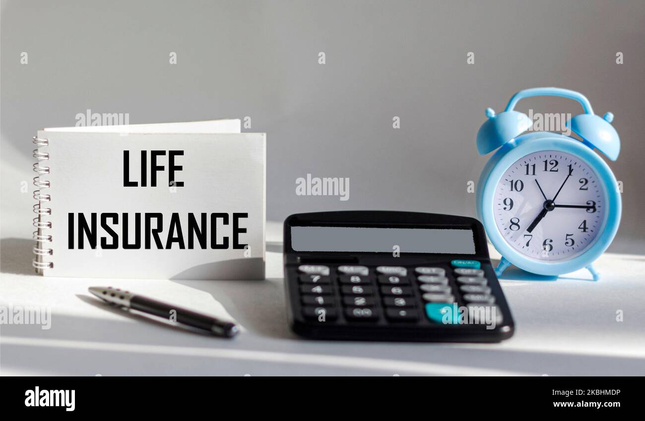 Life insurance word on notepad and white background with calculator ...