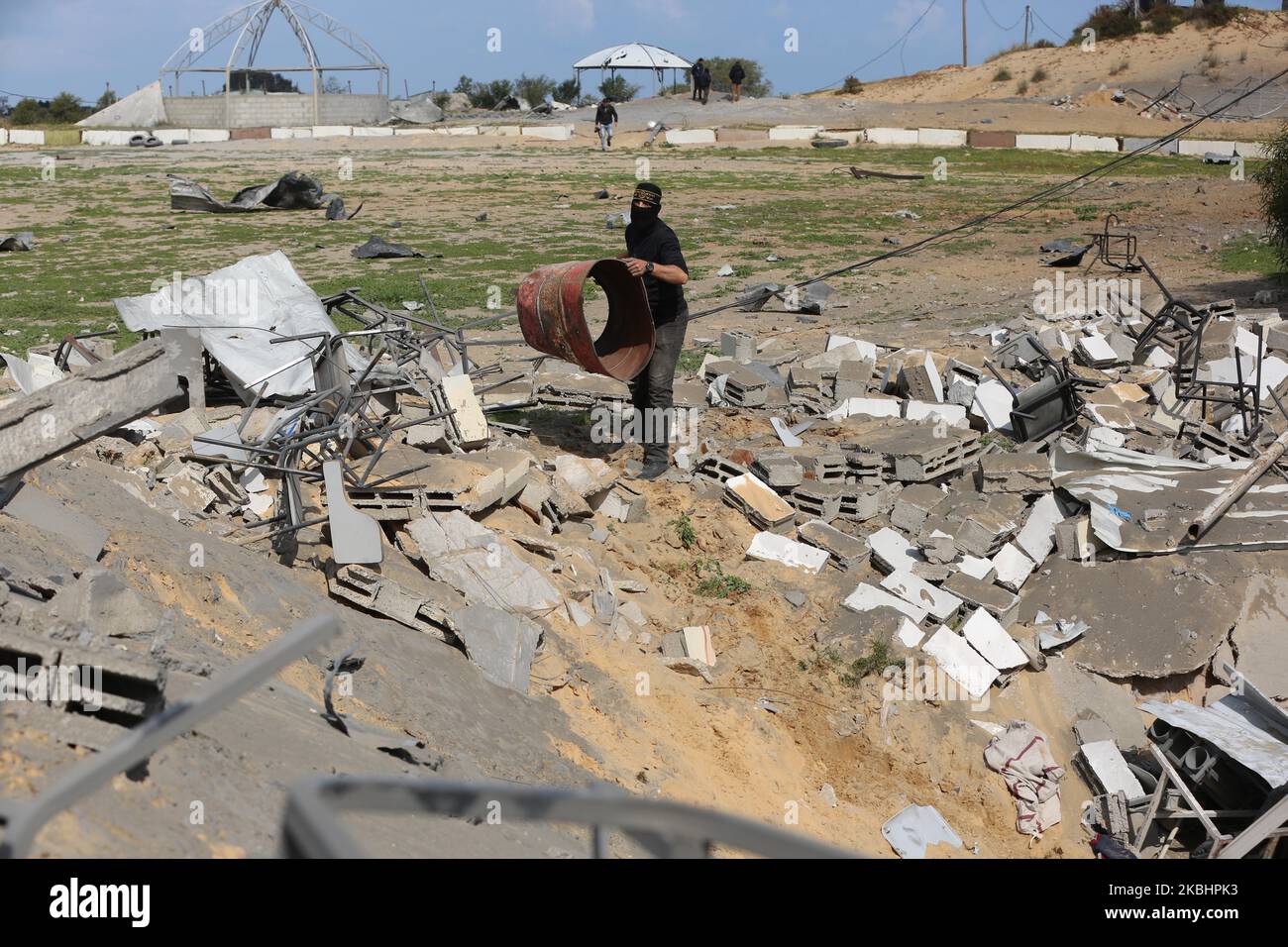A masked Palestinian militant checks the damage following overnight ...