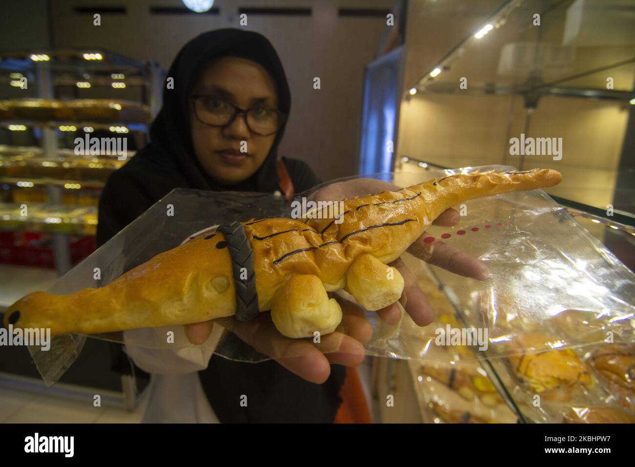 A buyer shows crocodile-shaped bread caught in a used tire at a bakery ...