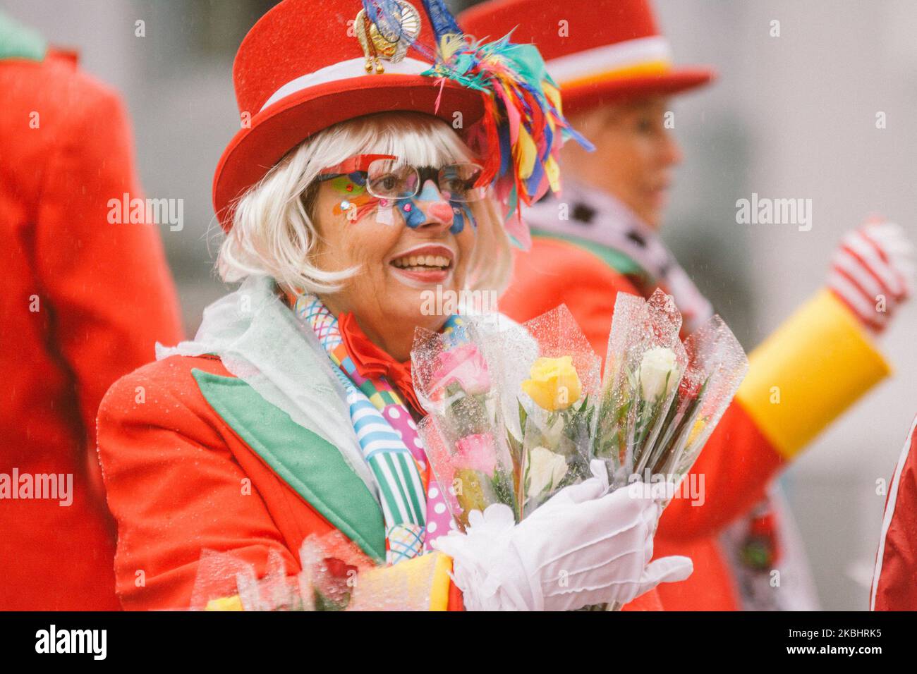 A member of Rose Monday Parade throws the flower to the crowd during ...
