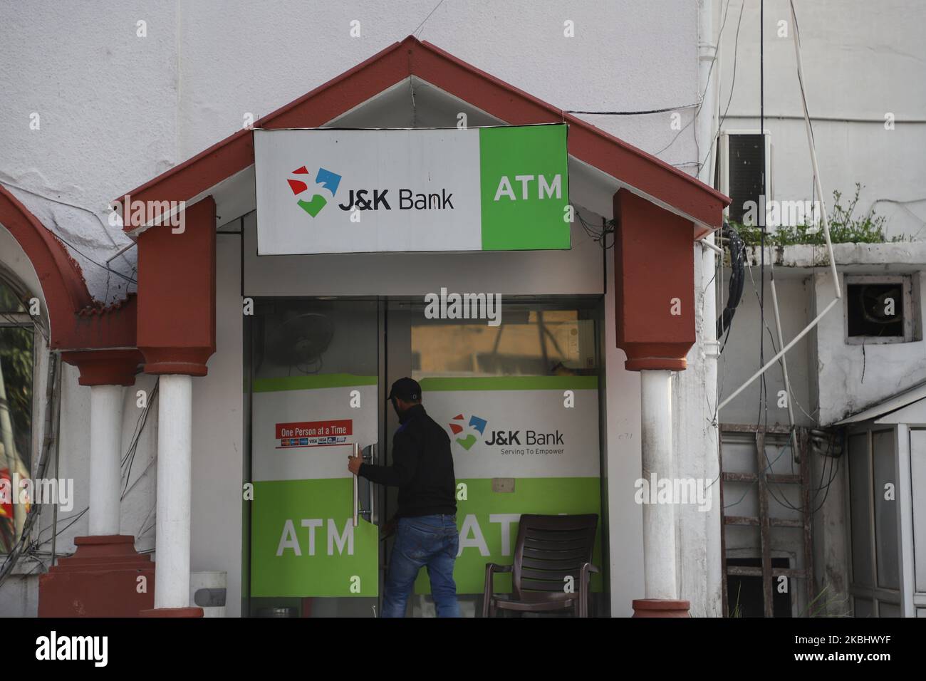 A man enters Jammu and Kashmir bank ATM in Jammu City on 25 February ...