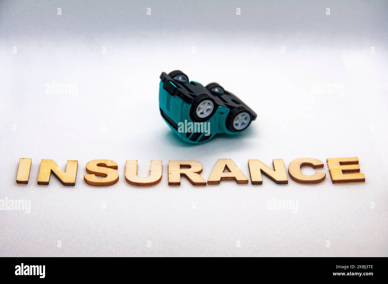 Insurance wooden text and model car turning up-side-down. Security and ...