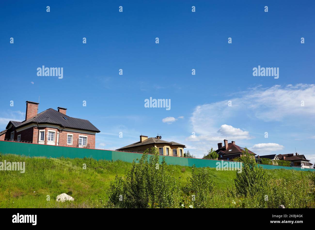 Facade of a European suburban buildings. Metal fence and house against ...