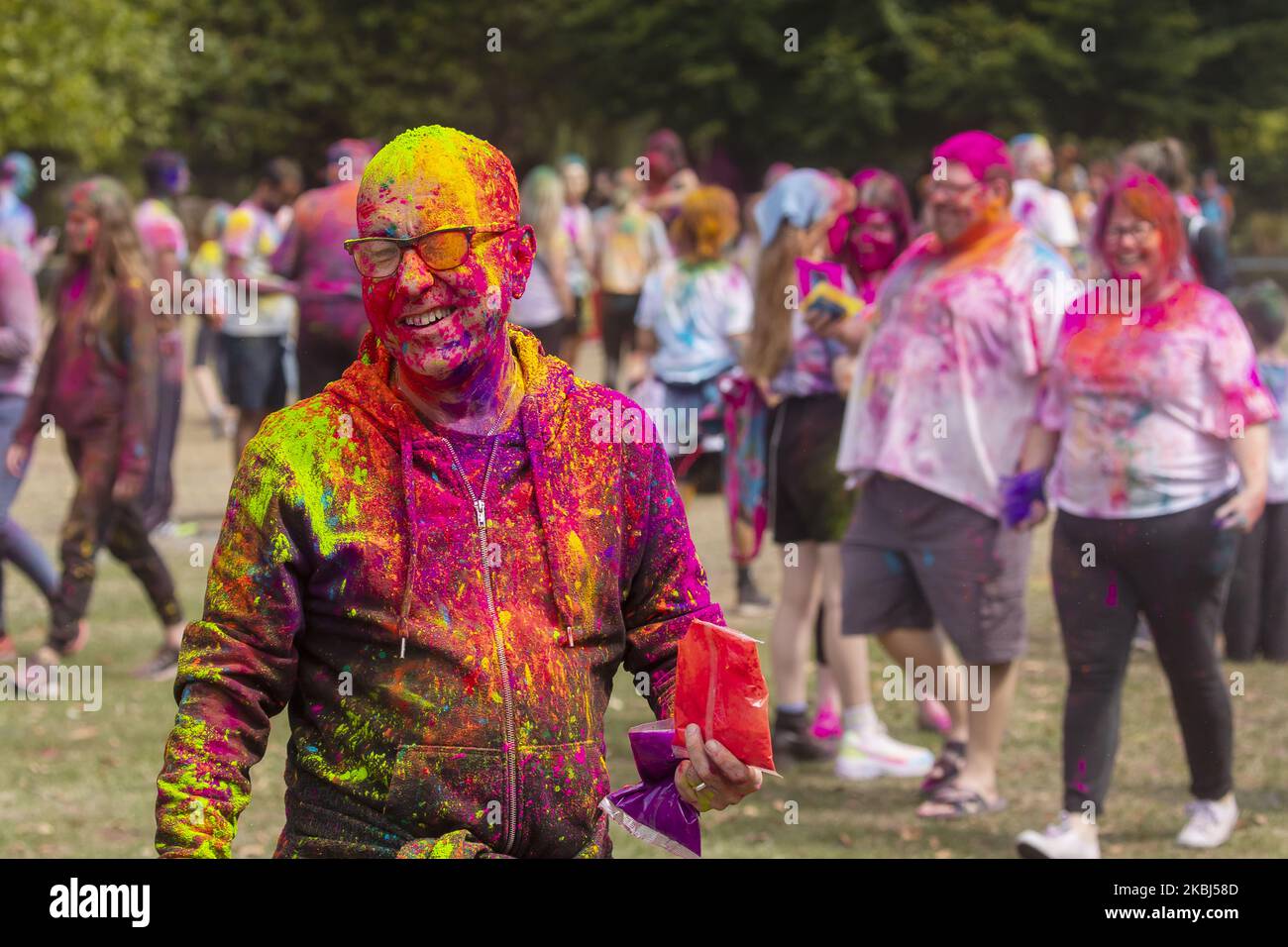 A man covered in colored powder reacts during the annual Holi festival ...