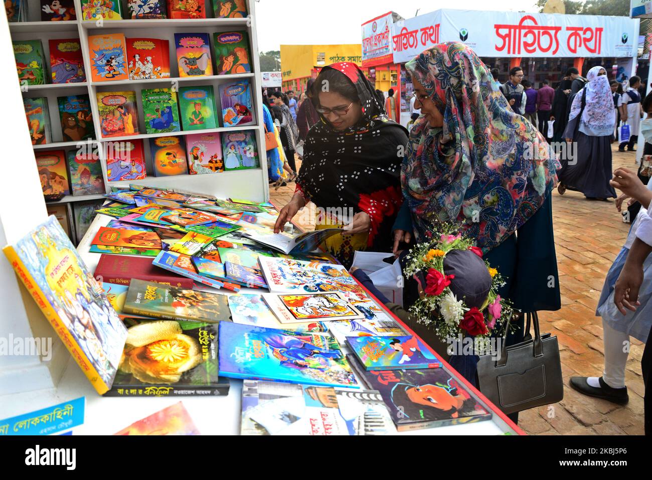 Visitors check books at a stall during 'Ekushey Boi Mela' book fair in ...