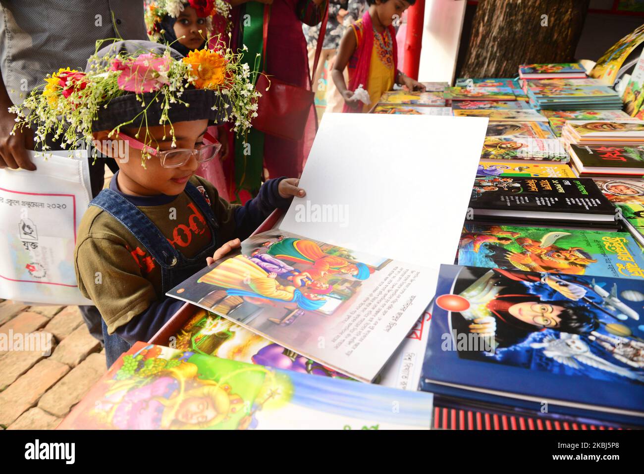 Visitors check books at a stall during 'Ekushey Boi Mela' book fair in ...
