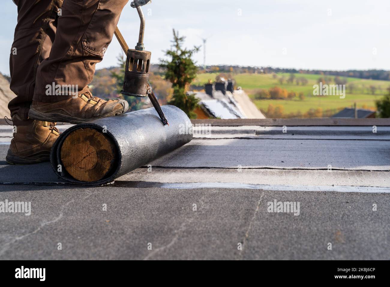 Worker Heating and melting bitumen roofing Flat roof installation Stock Photo - Alamy