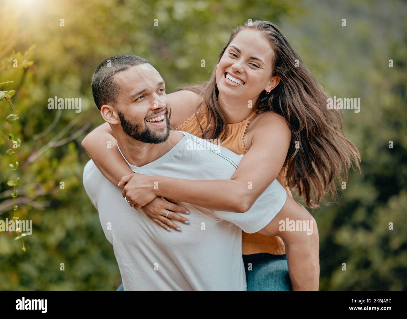 Love, fun and nature couple hug while playing, happy and enjoy outdoor ...