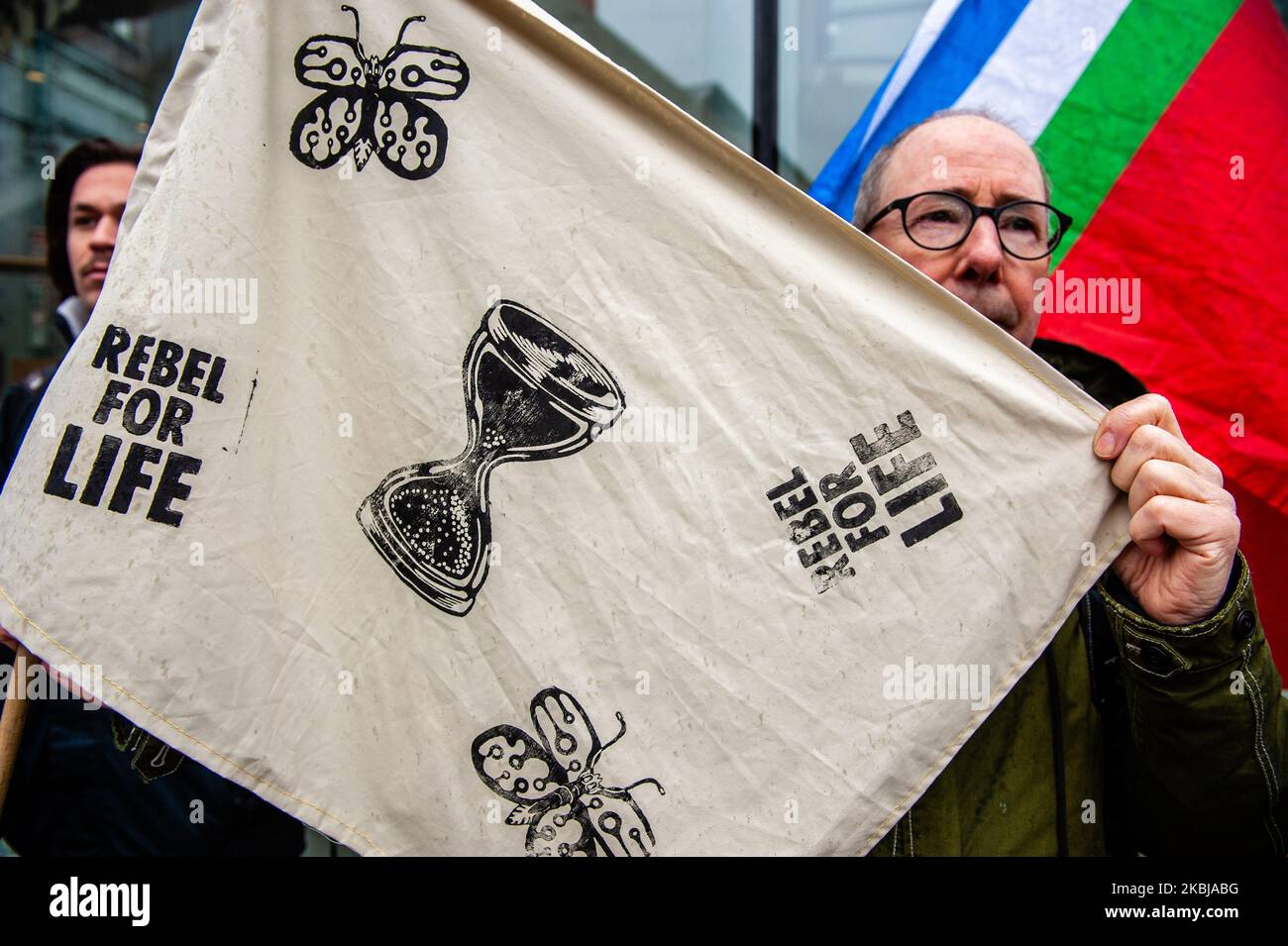 An XR activist is seen holding a flag of Extinction Rebellion in front ...