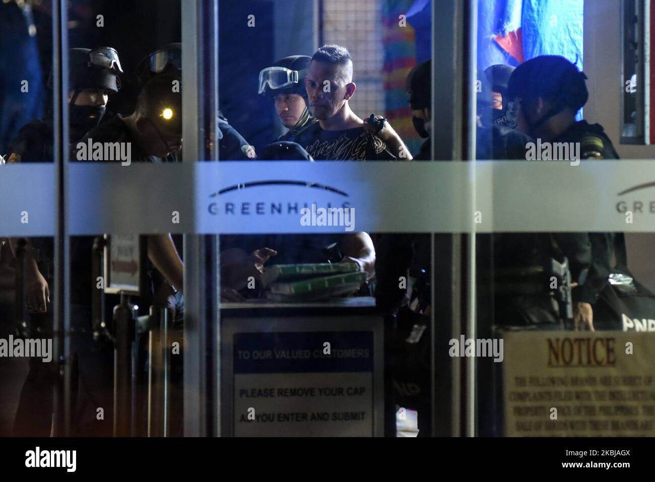 Police officers secure the suspect inside a mall in San Juan City, east ...