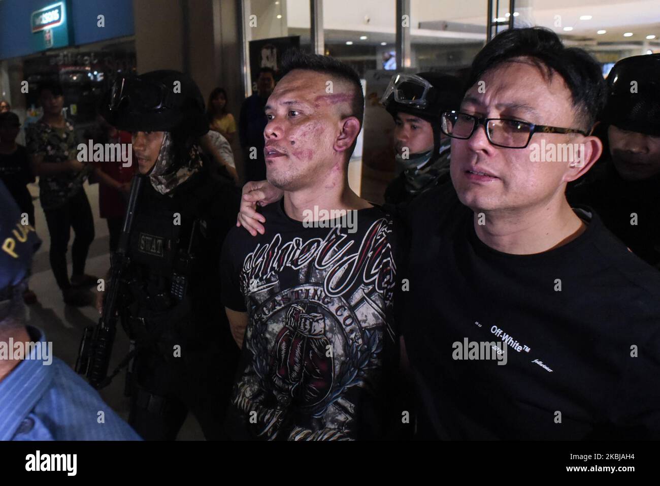 Police officers secure the suspect outside a mall in San Juan City ...