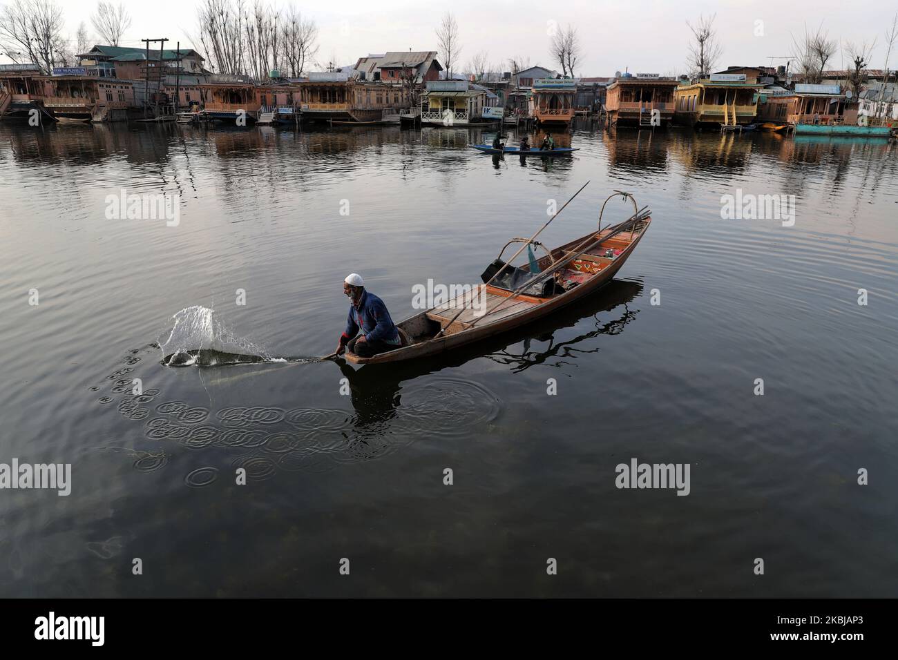 A fisherman rows his boat in the famous Dal Lake in Srinagar, Jammu and ...