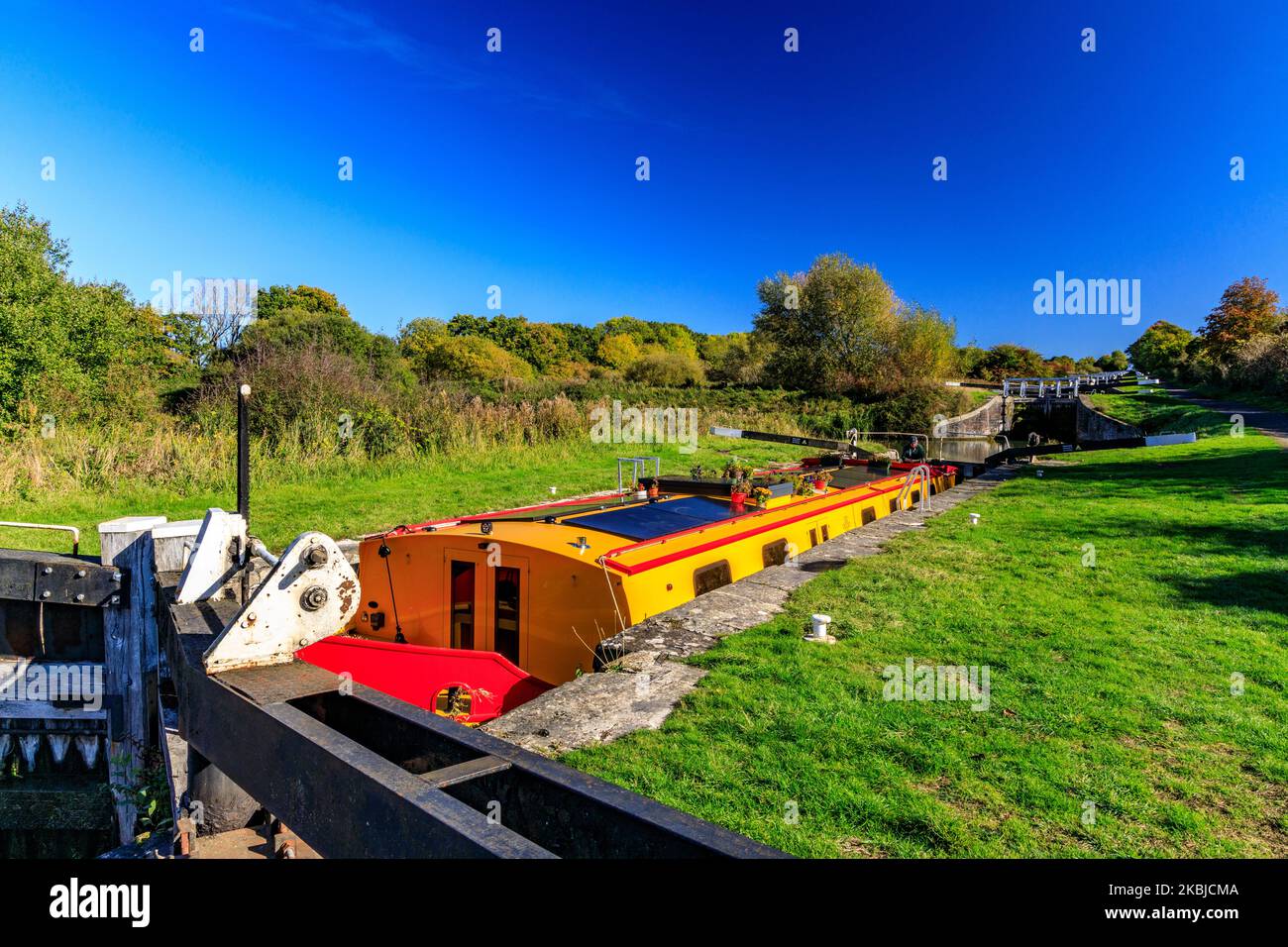 A colourful wide beam canal boat negotiating one of the 29 locks at ...